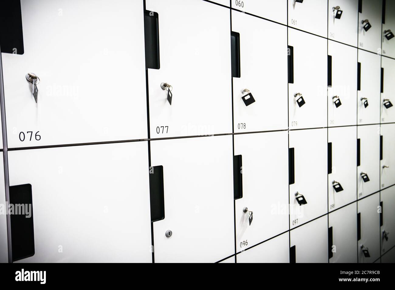 Closeup shot of rows of small white numbered lockers with keys Stock ...