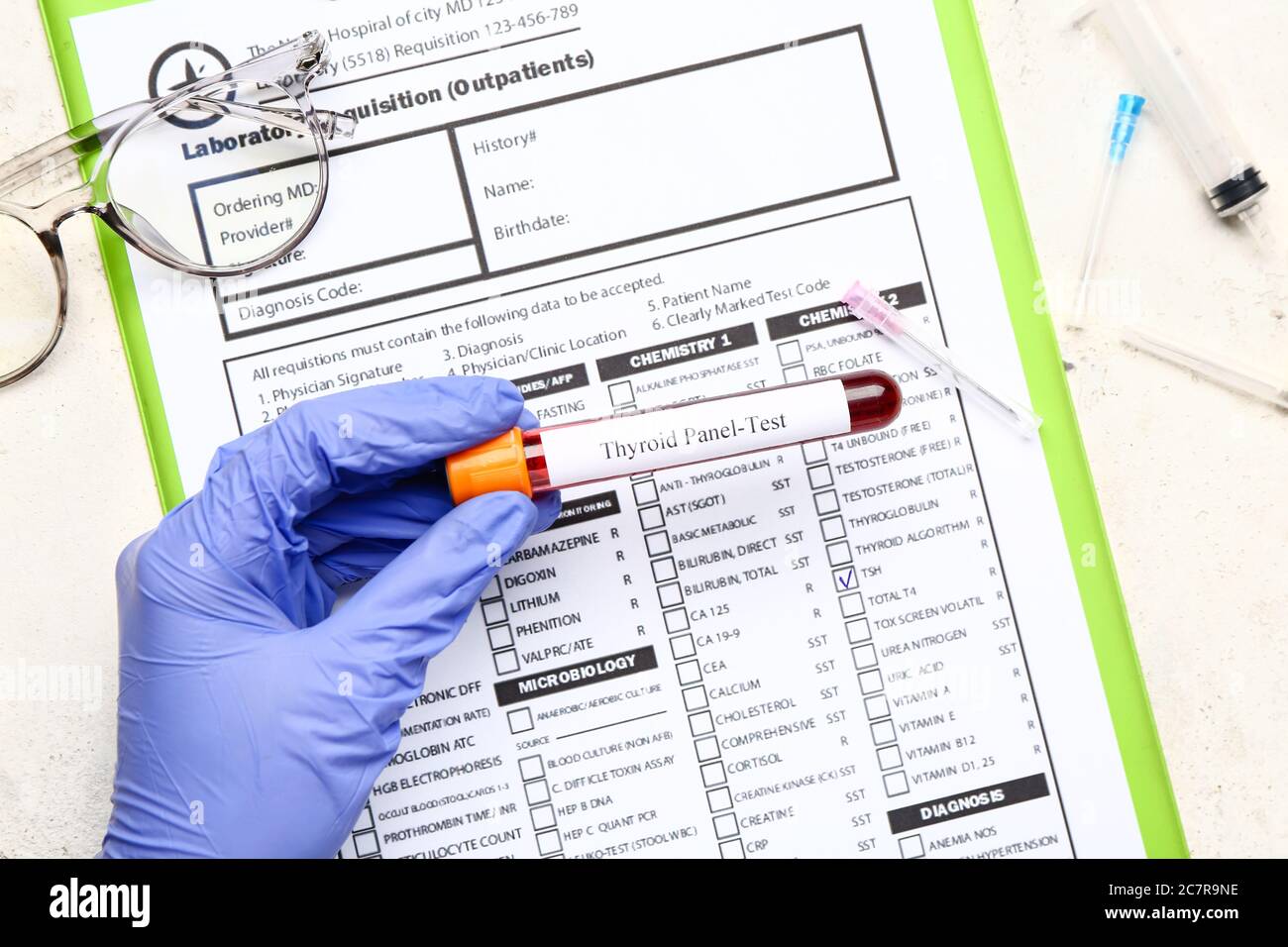 Hand of doctor with blood sample in tube and laboratory test form, top ...