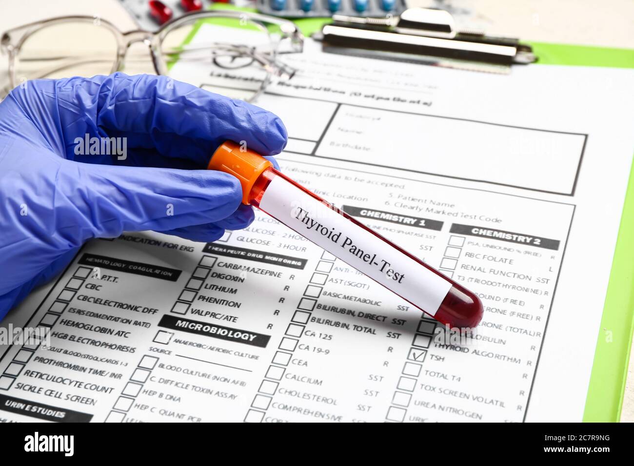 Hand of doctor with blood sample in tube and laboratory test form ...