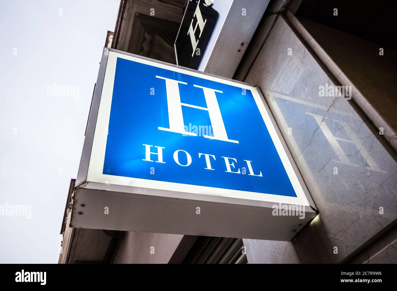 Low angle shot of a square blue sign with a large letter H and the word ...