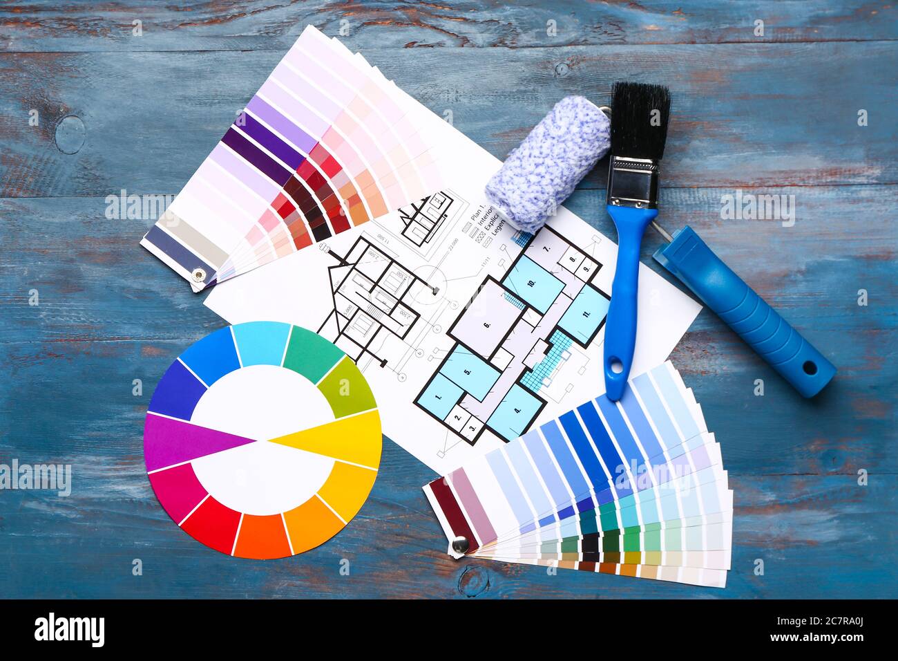 Color palettes with paint brush, roller and building plan on wooden ...