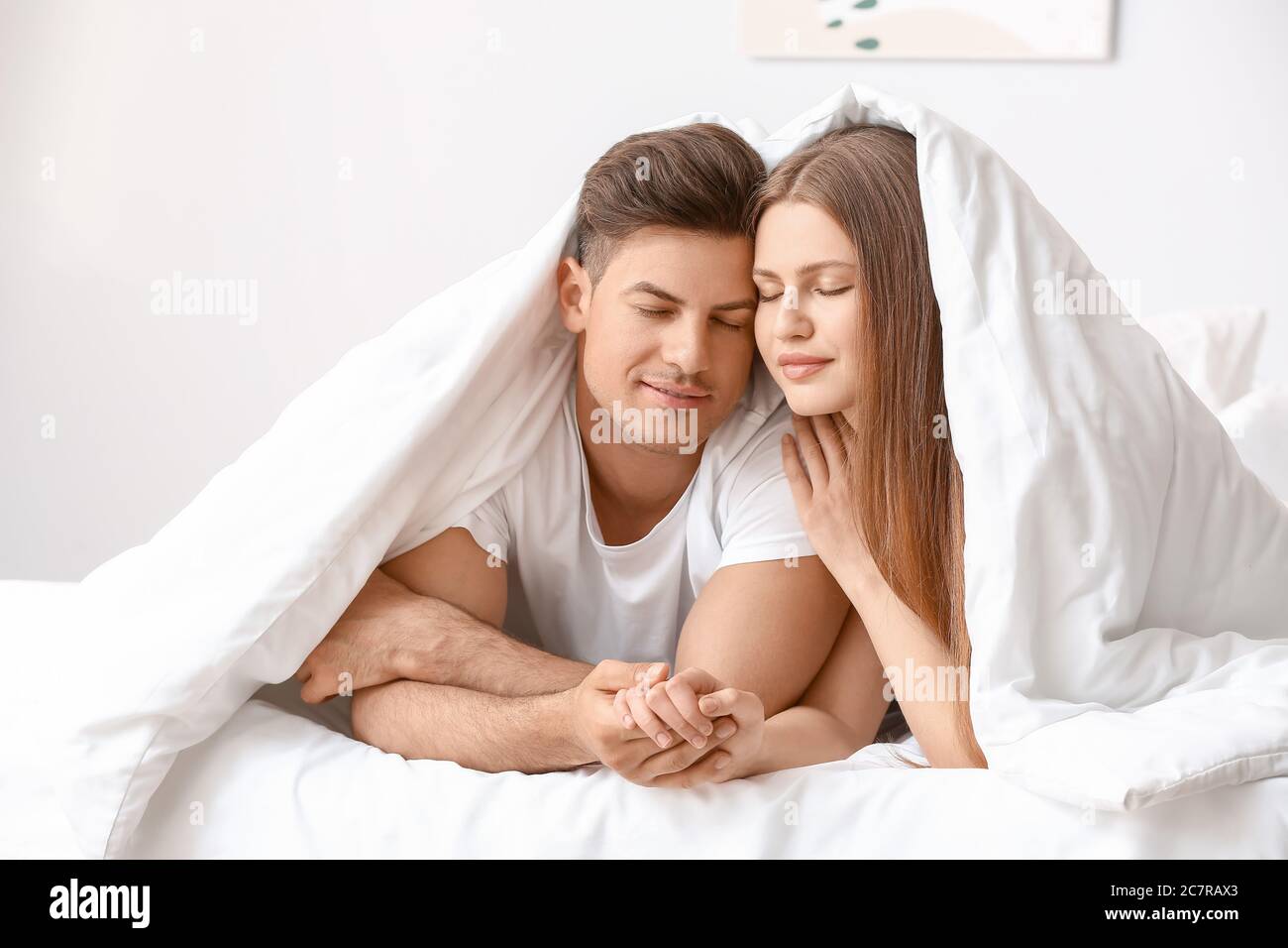 Morning of happy young couple in bed Stock Photo - Alamy