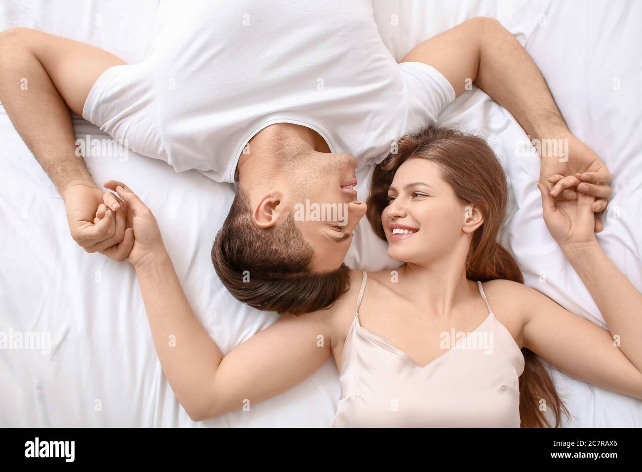 Morning of happy young couple lying in bed Stock Photo - Alamy