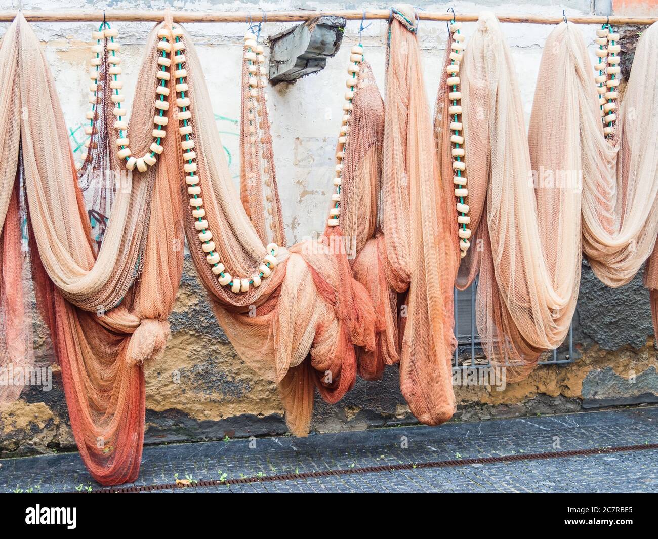Front view of colorful fishing nets, white beads, and ropes hanging ...