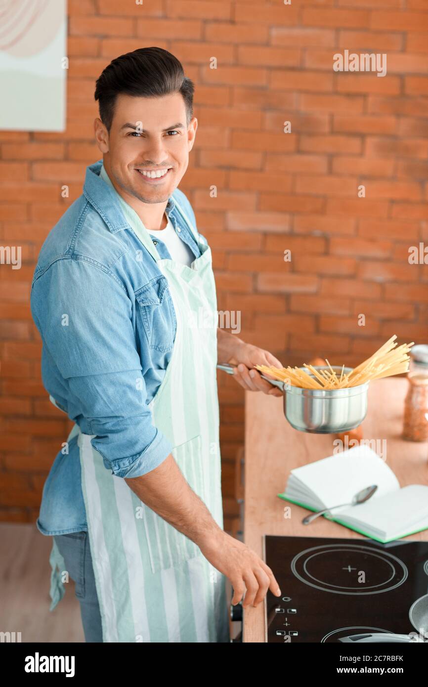 Young man boiling pasta in kitchen Stock Photo - Alamy