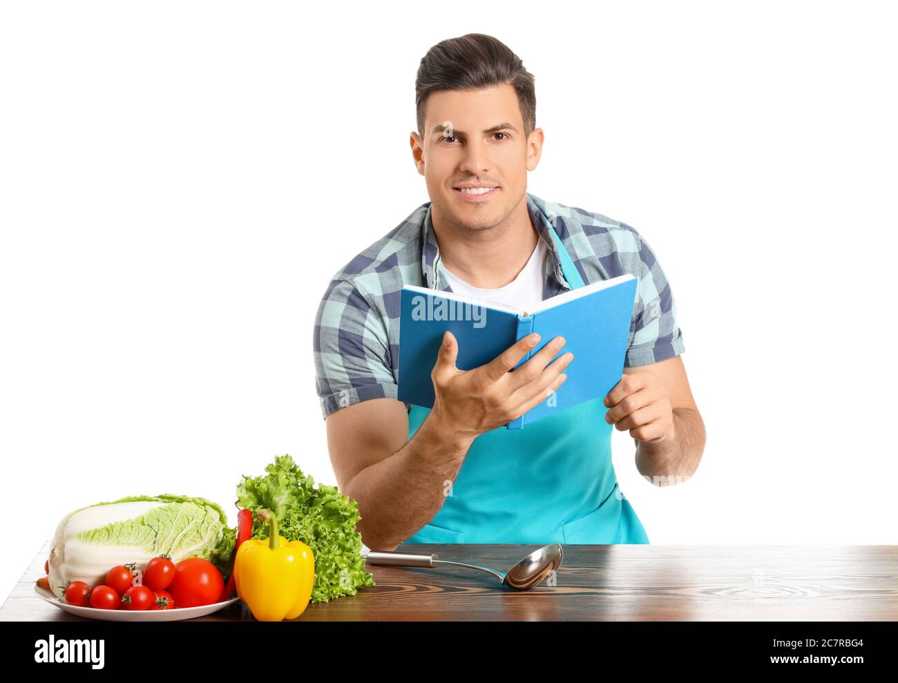 Young man with recipe book on white background Stock Photo - Alamy