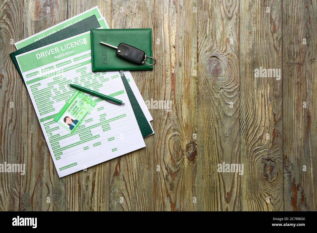 Driving license with application form, passport and car key on wooden ...
