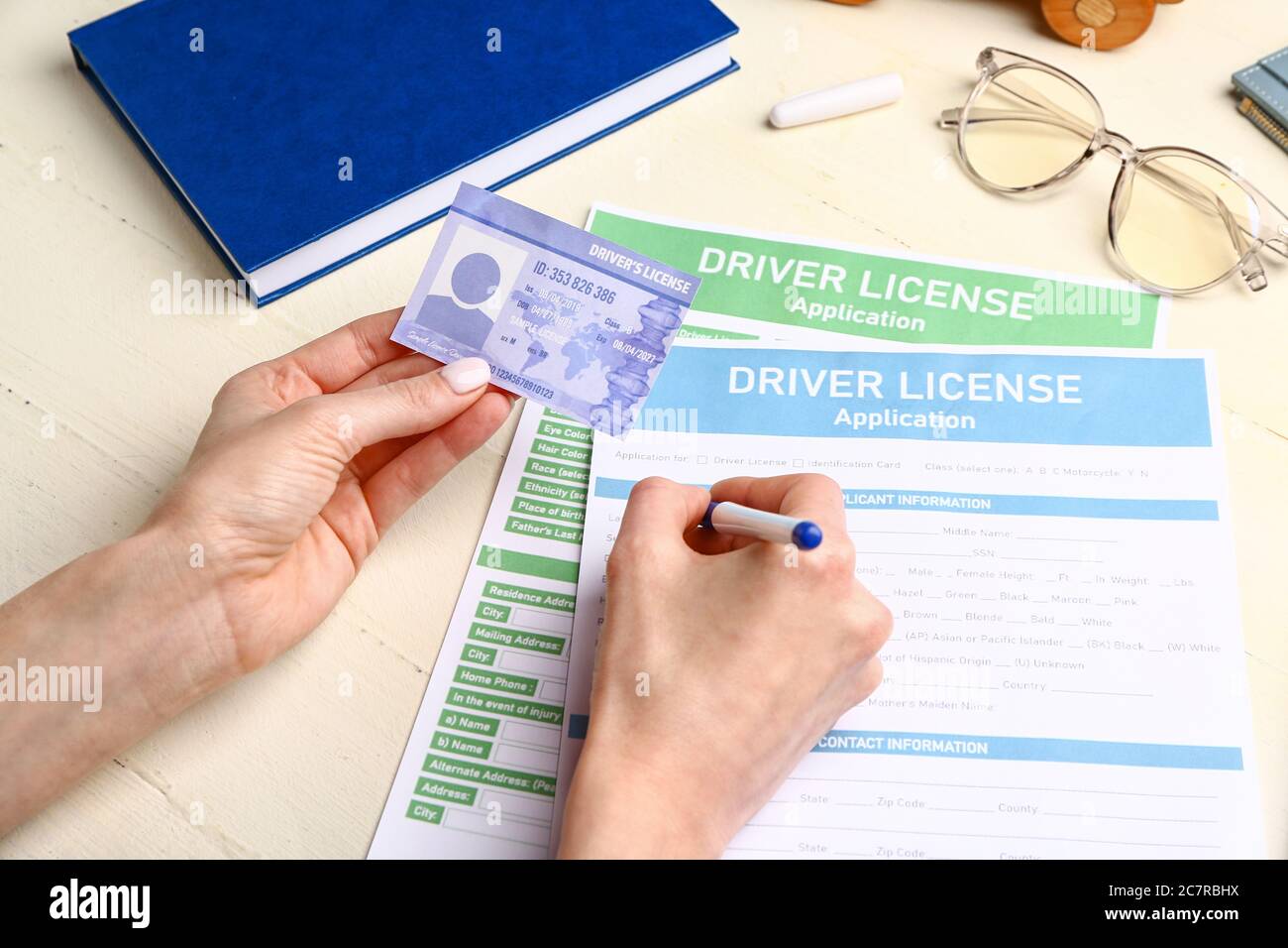 Woman filling in driver license application at table Stock Photo - Alamy