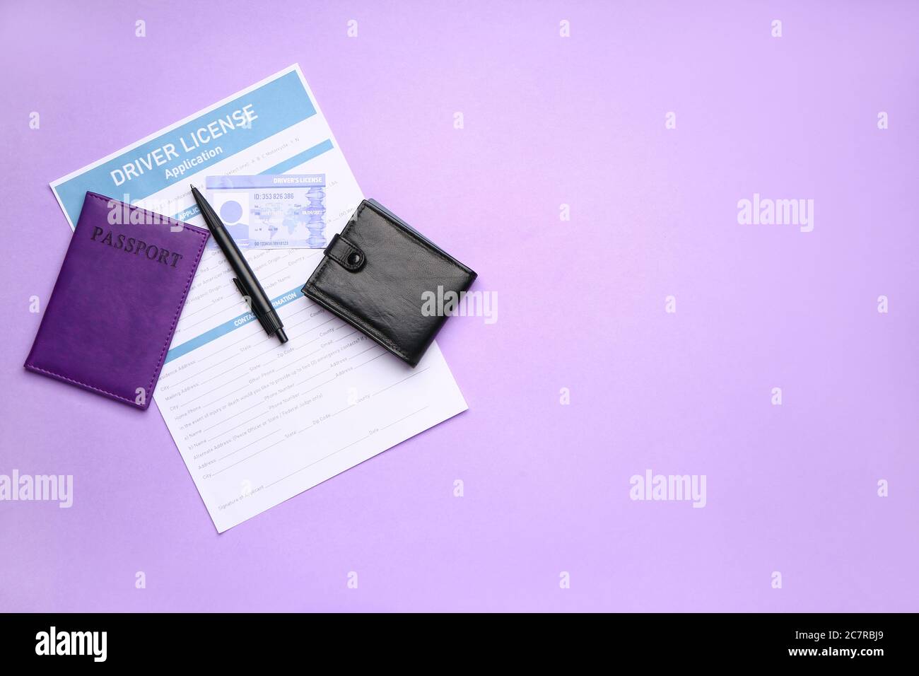Driving license with application form, passport and wallet on color ...
