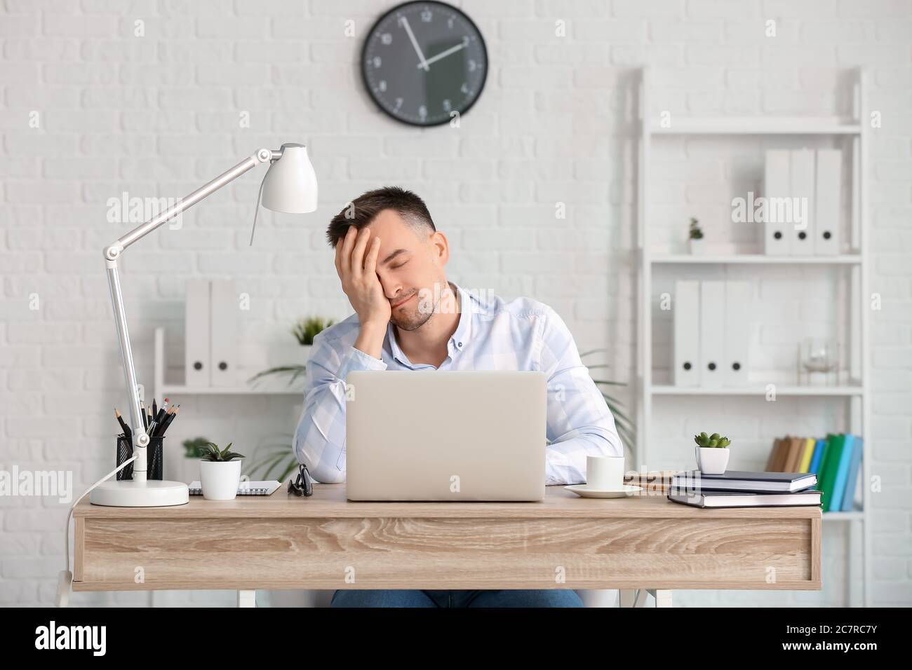 Tired man working in office. Concept of sleep deprivation Stock Photo ...