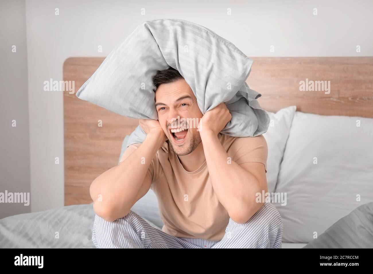 Young man suffering from sleep deprivation in bedroom Stock Photo - Alamy