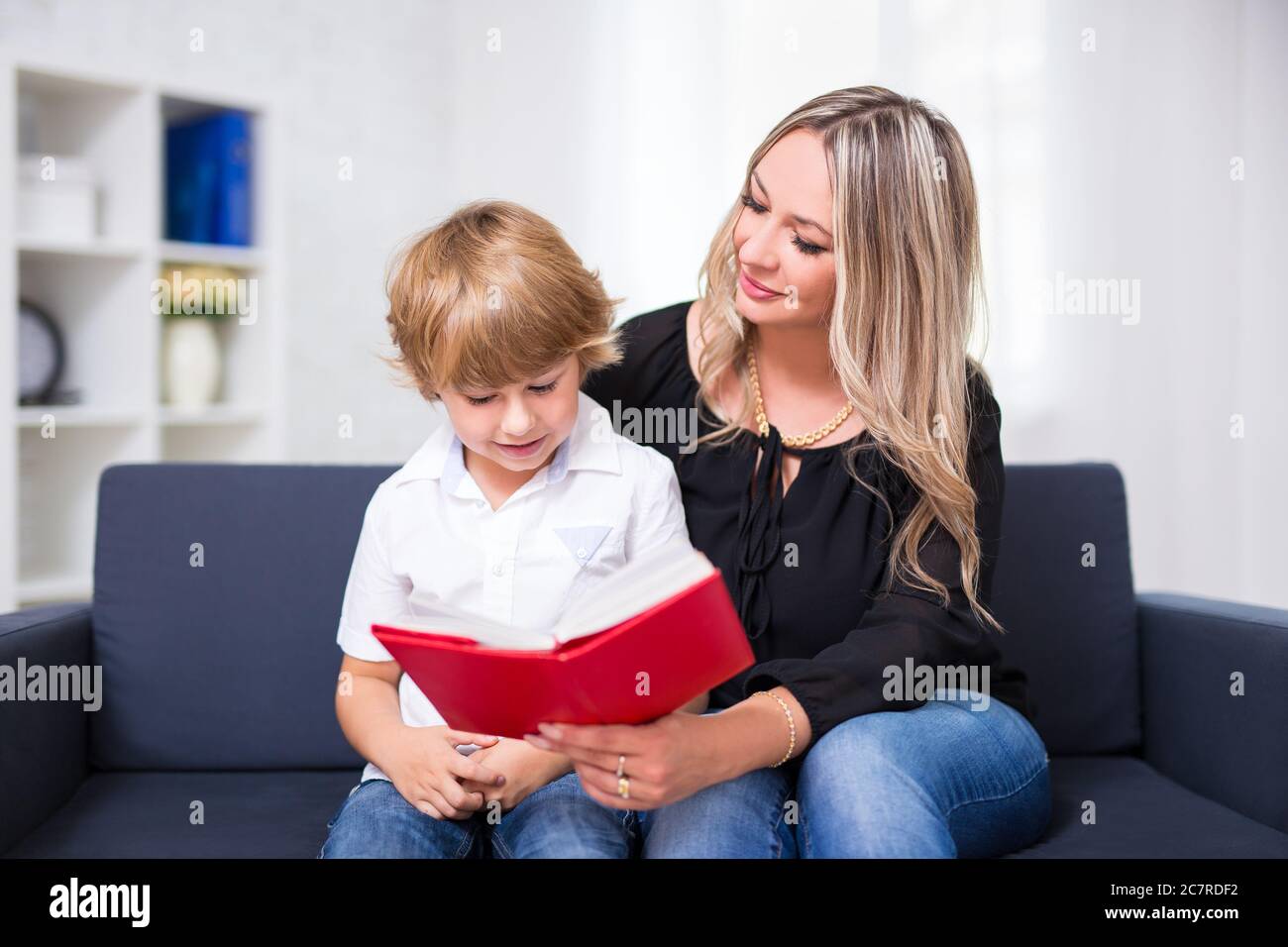 happy family portrait - young mother and her cute little son reading book together Stock Photo ...
