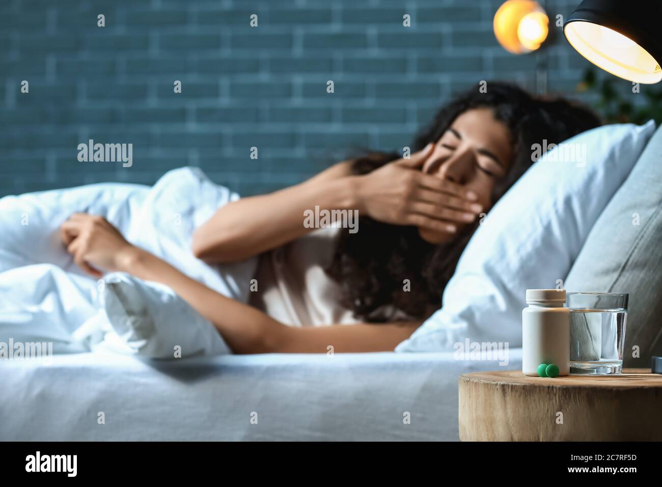 Sleeping pills on table in woman's bedroom at night Stock Photo - Alamy