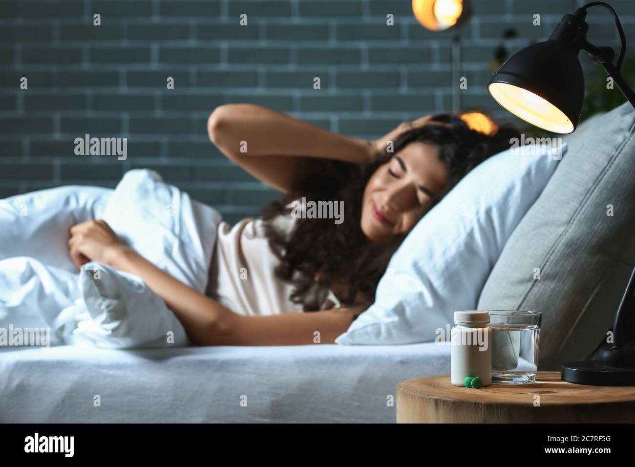 Sleeping pills on table in woman's bedroom at night Stock Photo - Alamy