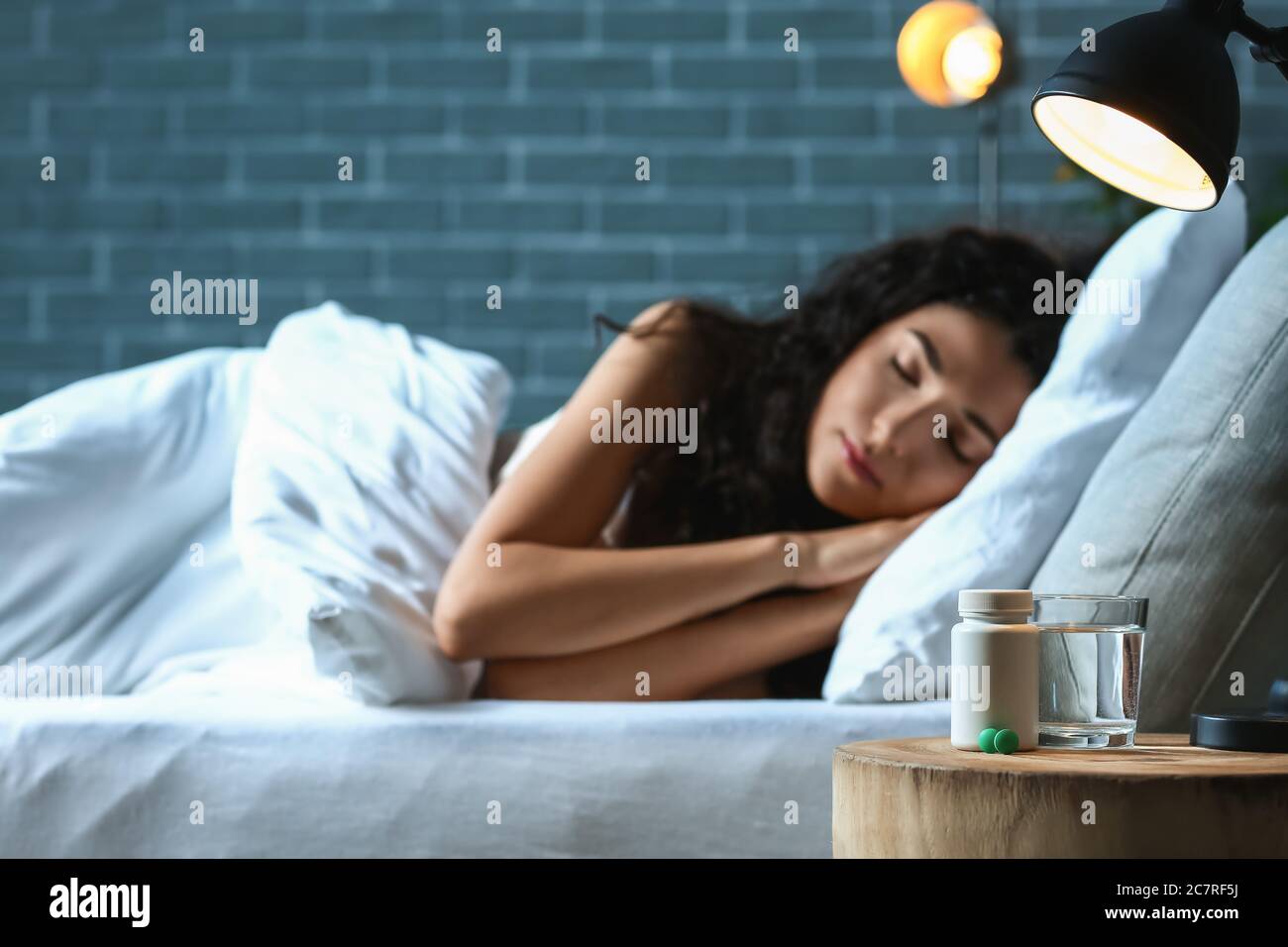 Sleeping pills on table in woman's bedroom at night Stock Photo - Alamy