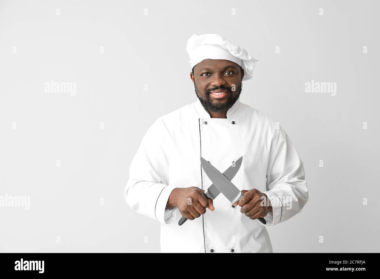 Male African-American chef with knives on white background Stock Photo ...