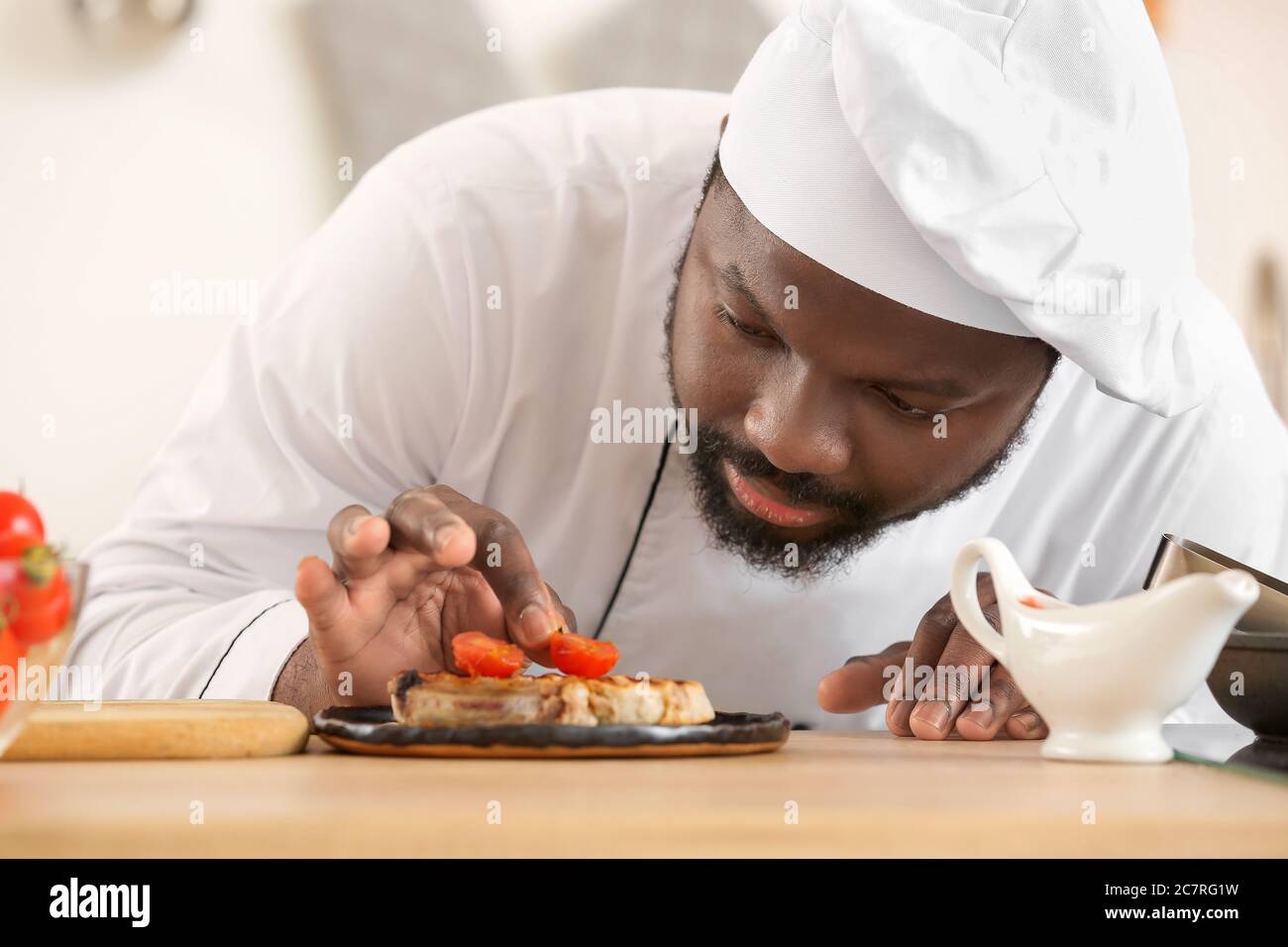 Male African-American chef cooking in kitchen Stock Photo - Alamy