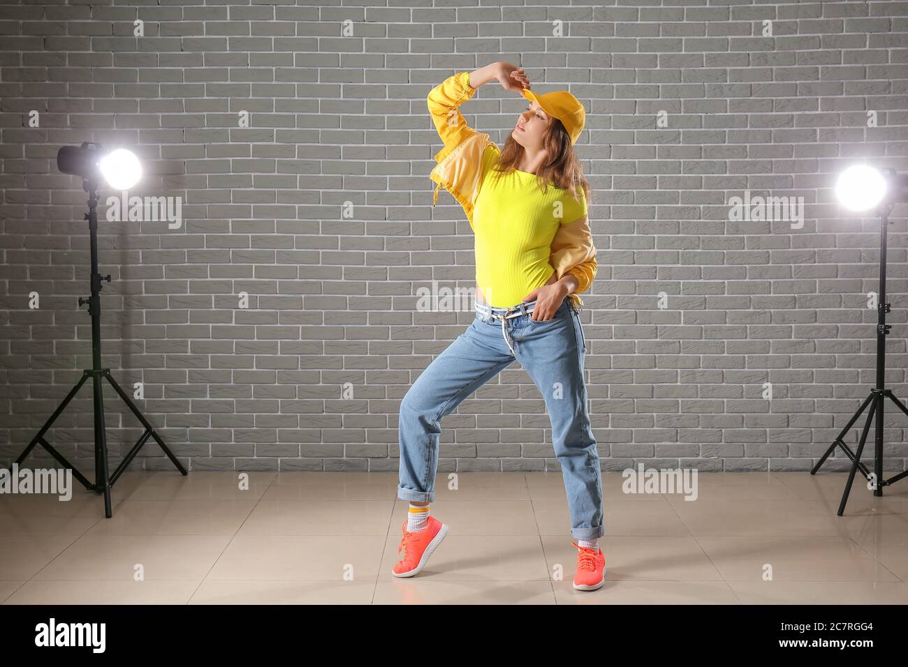 Beautiful female hip-hop dancer against brick wall Stock Photo - Alamy