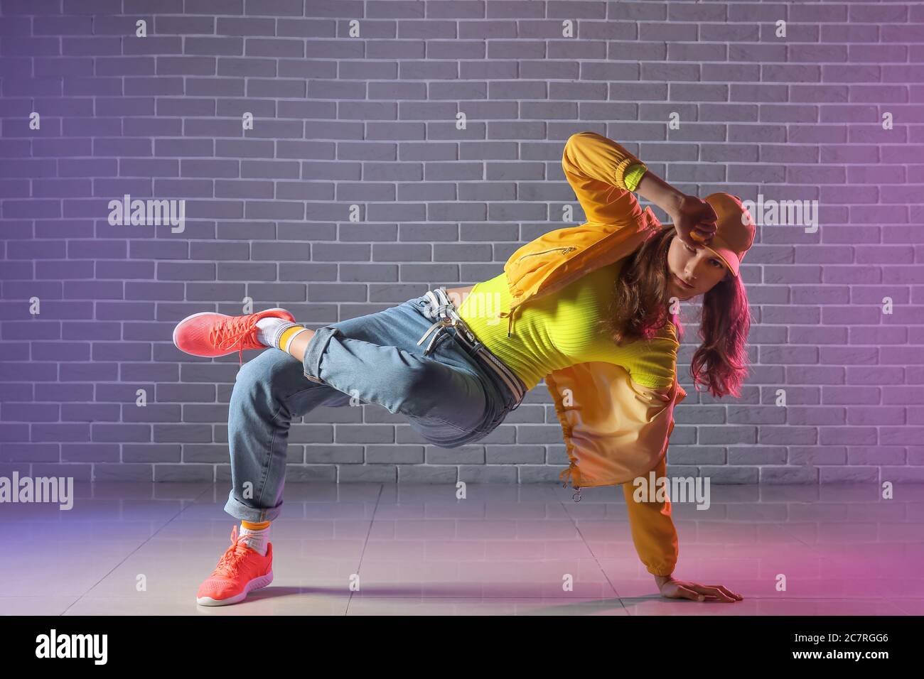 Beautiful female hip-hop dancer against brick wall Stock Photo - Alamy