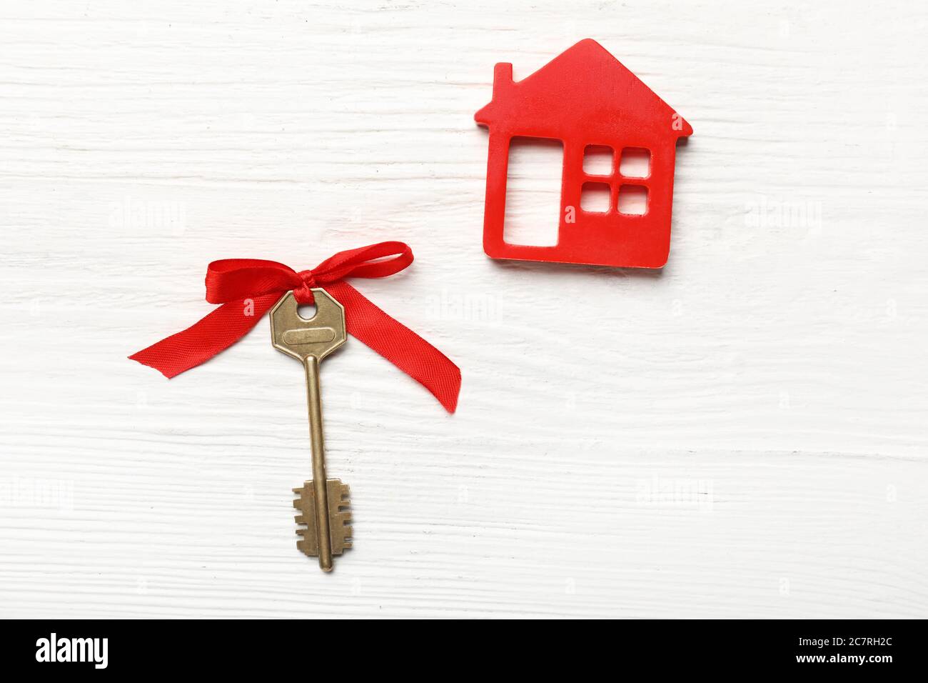 Key from house on white wooden background Stock Photo - Alamy