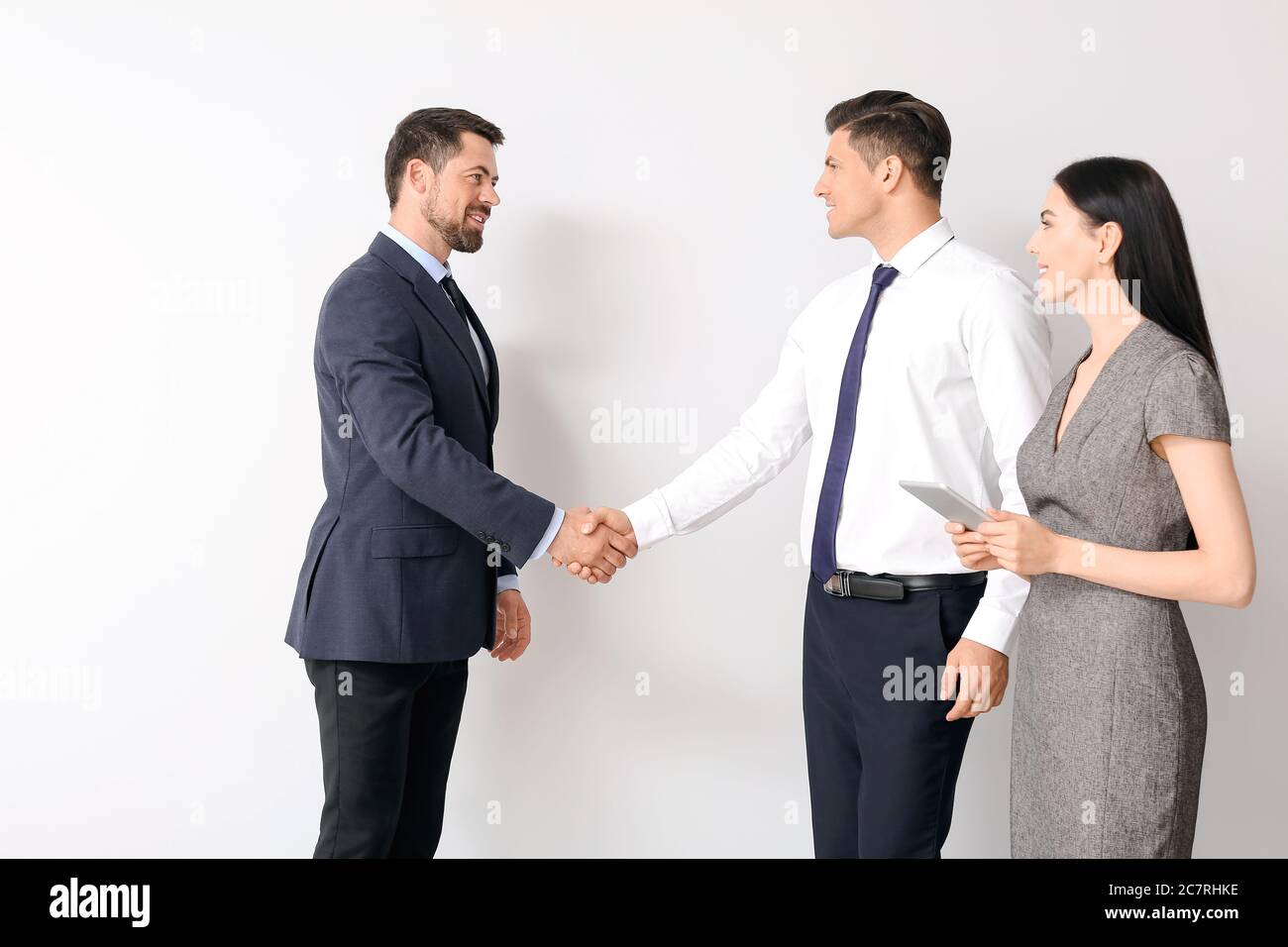 Business people shaking hands on light background Stock Photo - Alamy