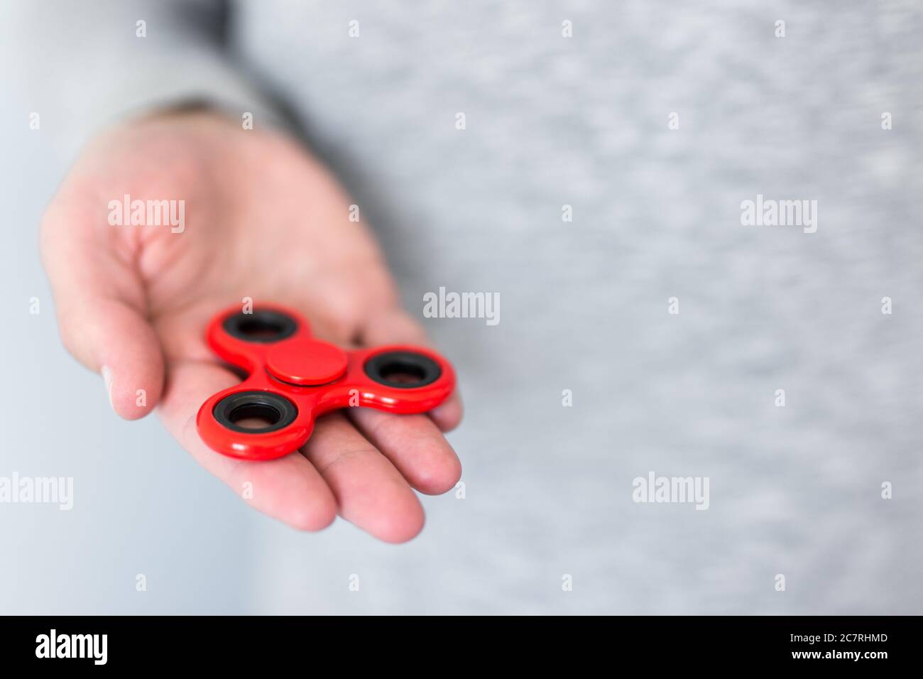 boy or man holding red fidget spinner in hand Stock Photo - Alamy