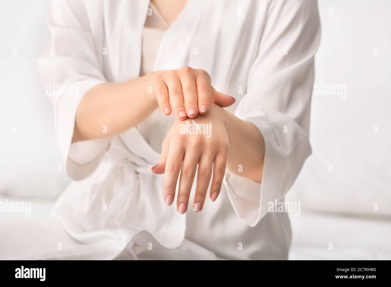 Beautiful young woman applying hand cream at home Stock Photo - Alamy