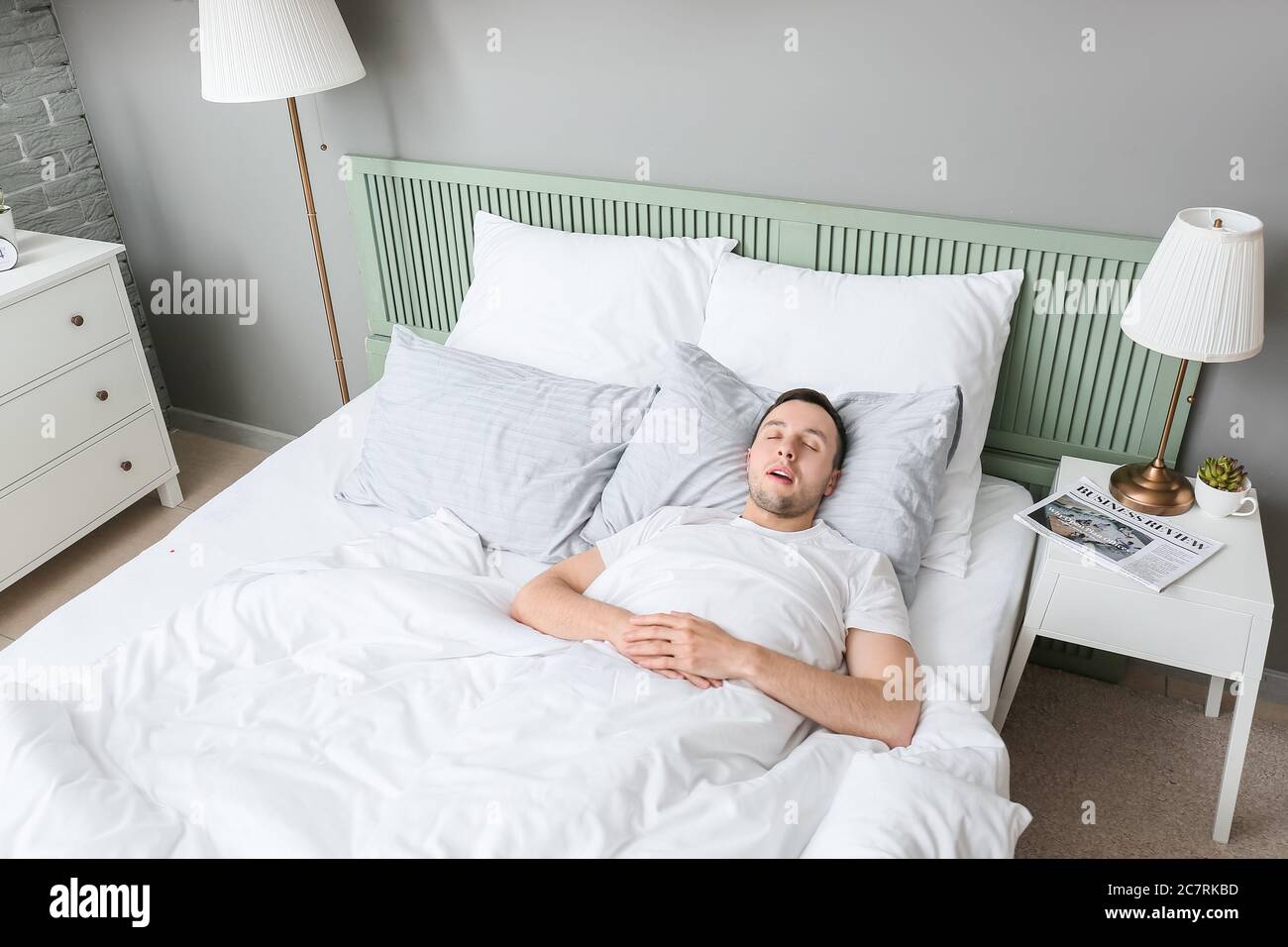 Young man snoring while sleeping in bed. Apnea problem Stock Photo - Alamy