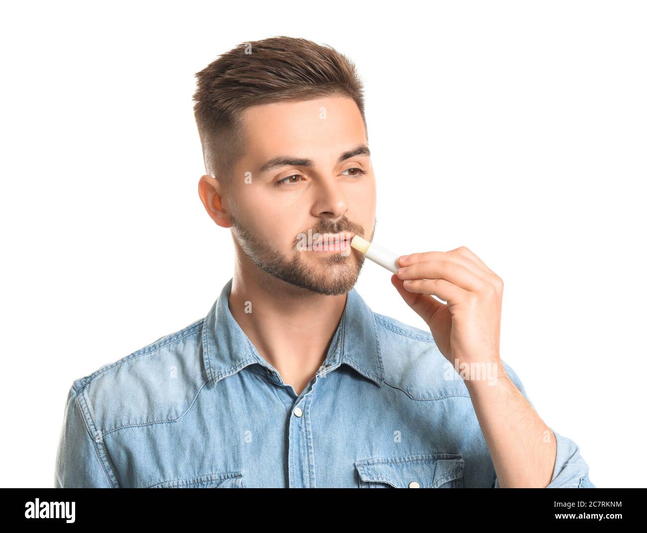 Handsome young man with lip balm on white background Stock Photo - Alamy