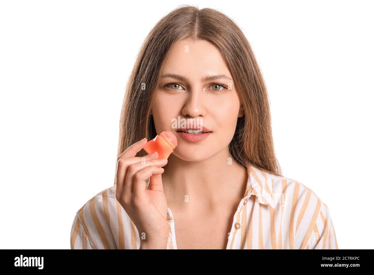 Beautiful young woman with lip balm on white background Stock Photo - Alamy