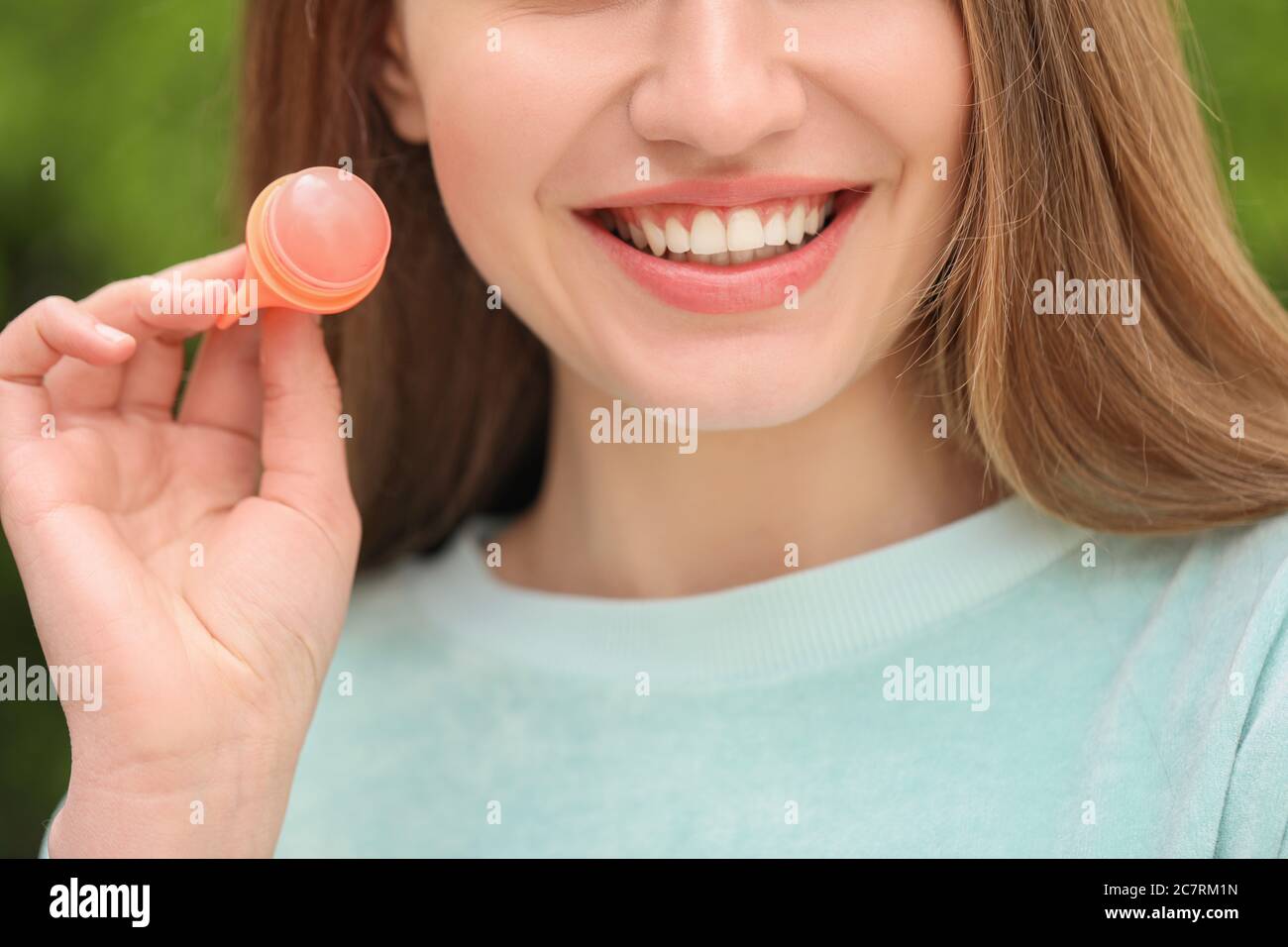 Beautiful young woman with lip balm outdoors, closeup Stock Photo - Alamy