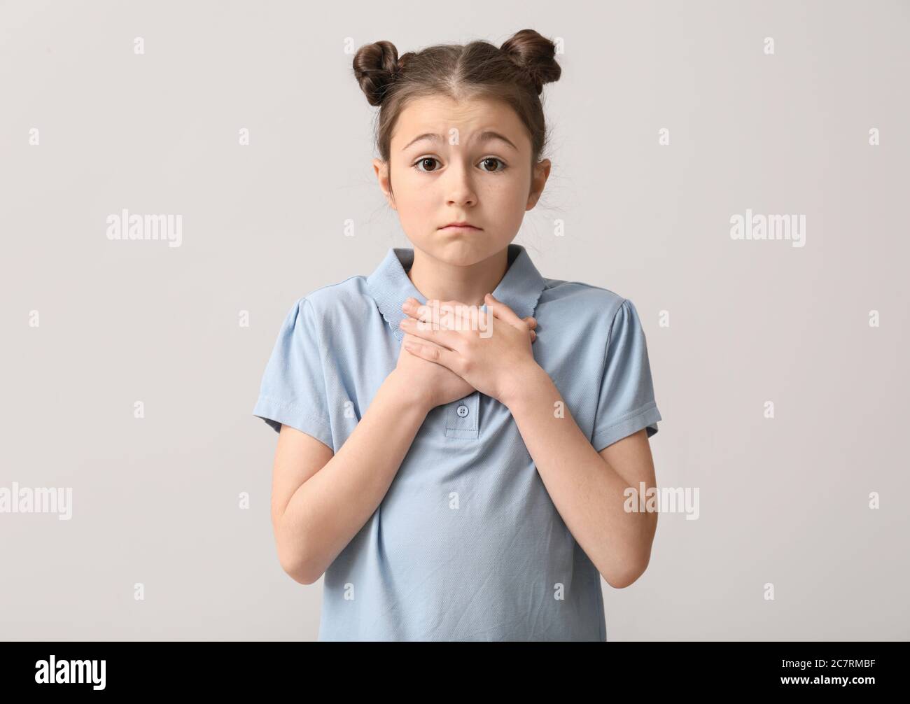 Apologizing little girl on light background Stock Photo - Alamy