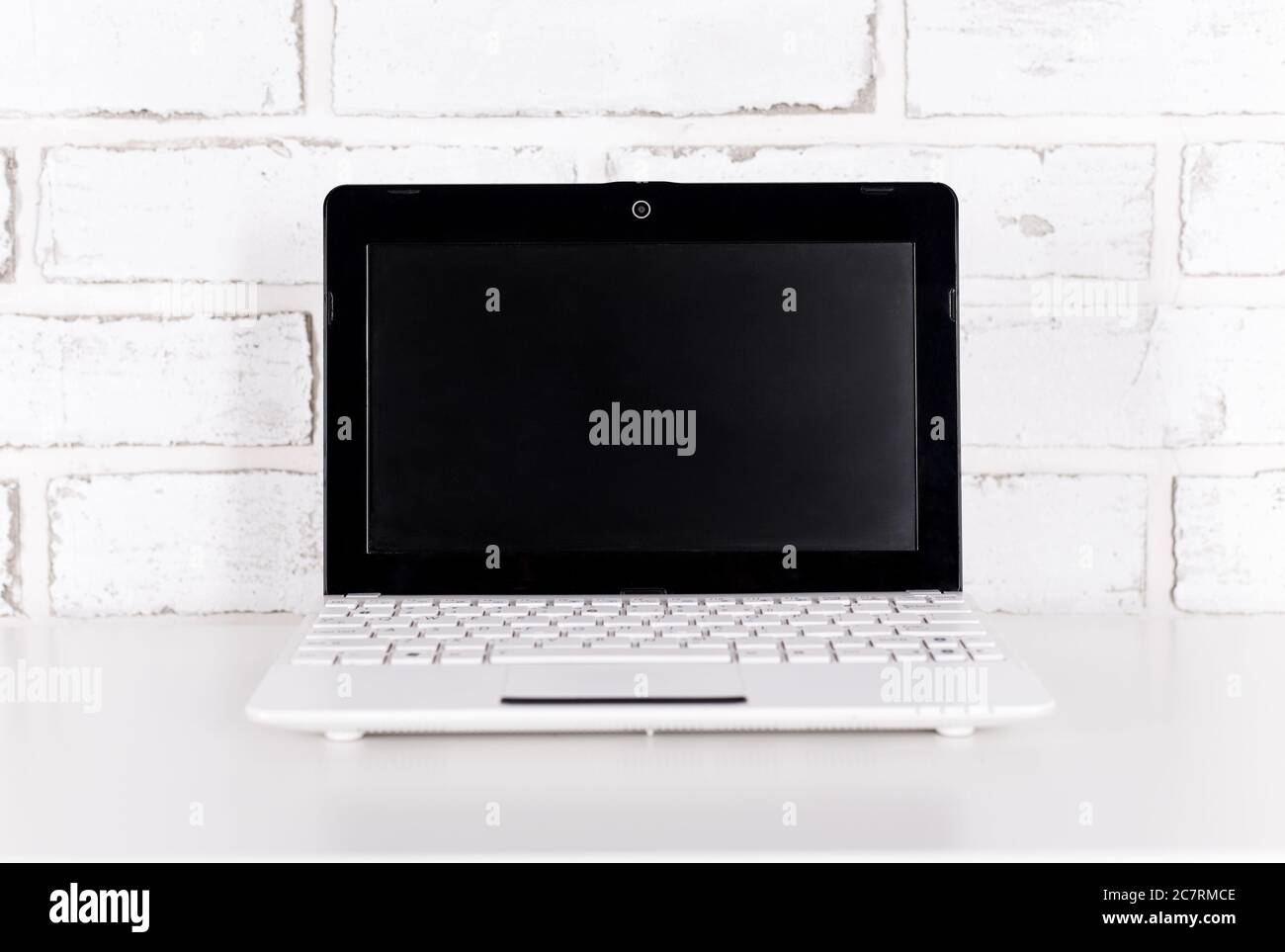 modern laptop over white brick wall background Stock Photo - Alamy
