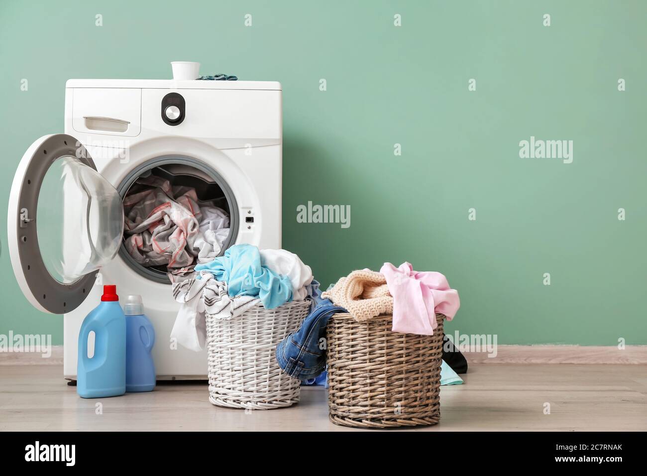 Washing machine with dirty clothes near color wall Stock Photo - Alamy
