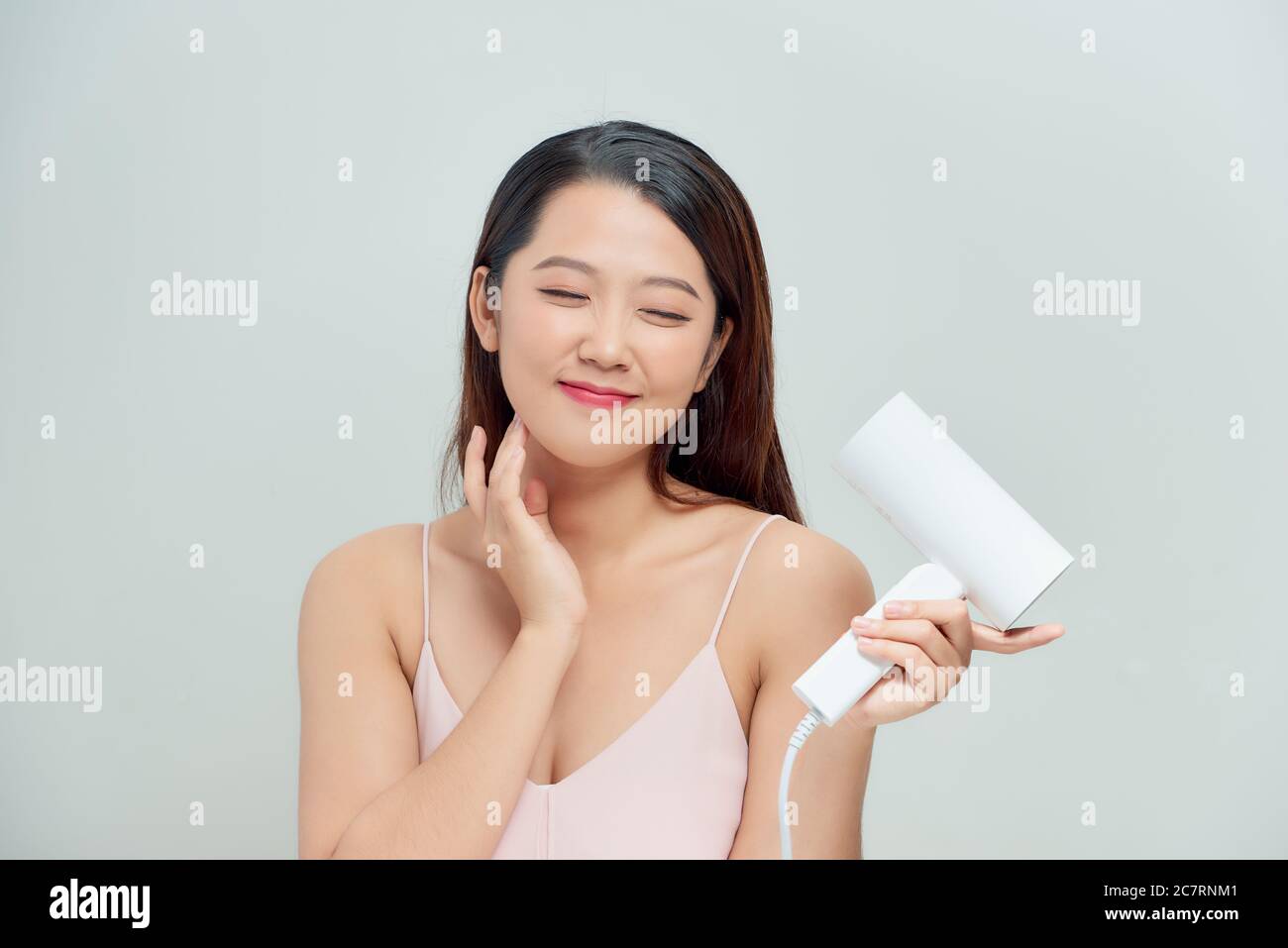 Hair Care. Beautiful smiling woman drying healthy long straight hair ...