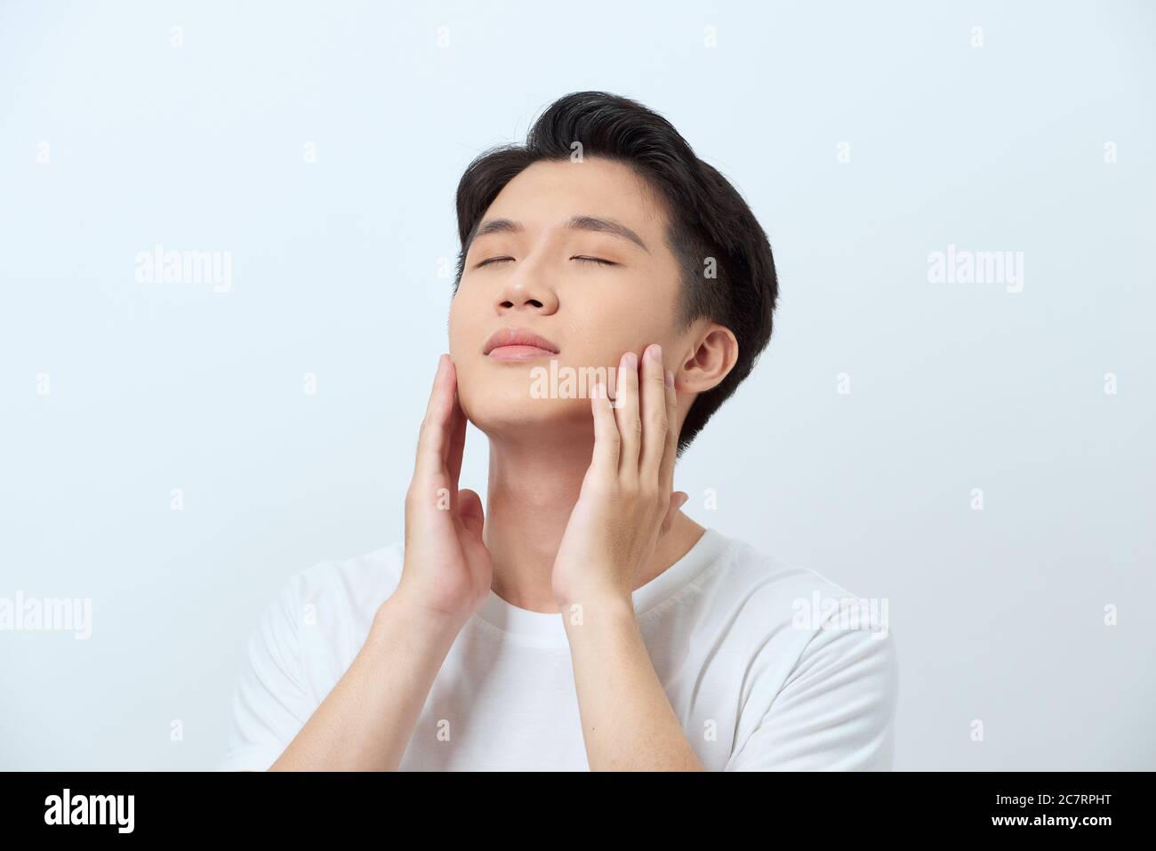 Handsome man touching his face close up portrait studio on white ...