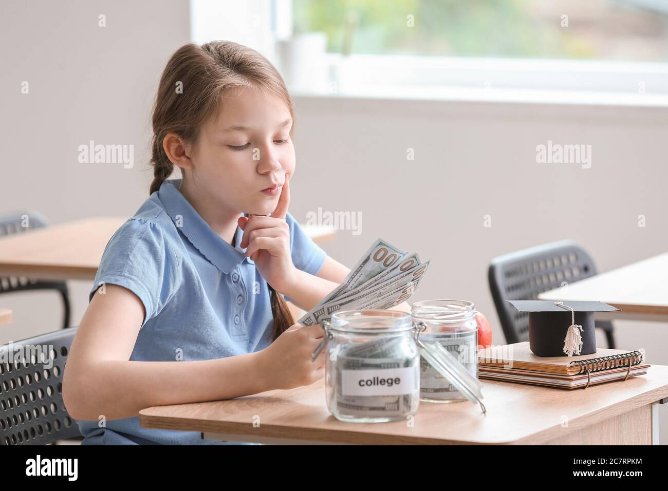 Girl school desk classroom money hi-res stock photography and images ...