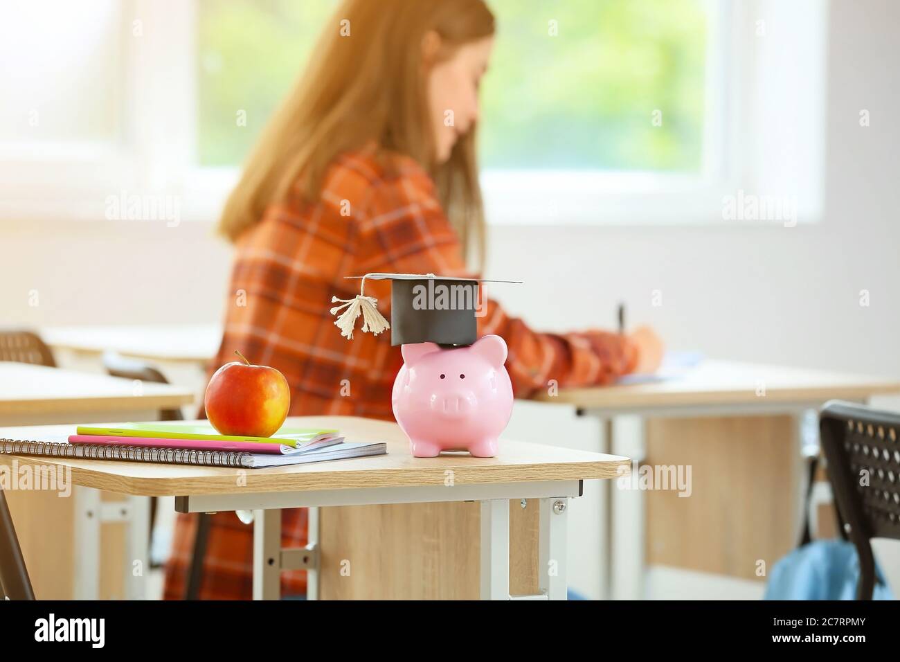 Piggy bank with savings for education in classroom Stock Photo - Alamy