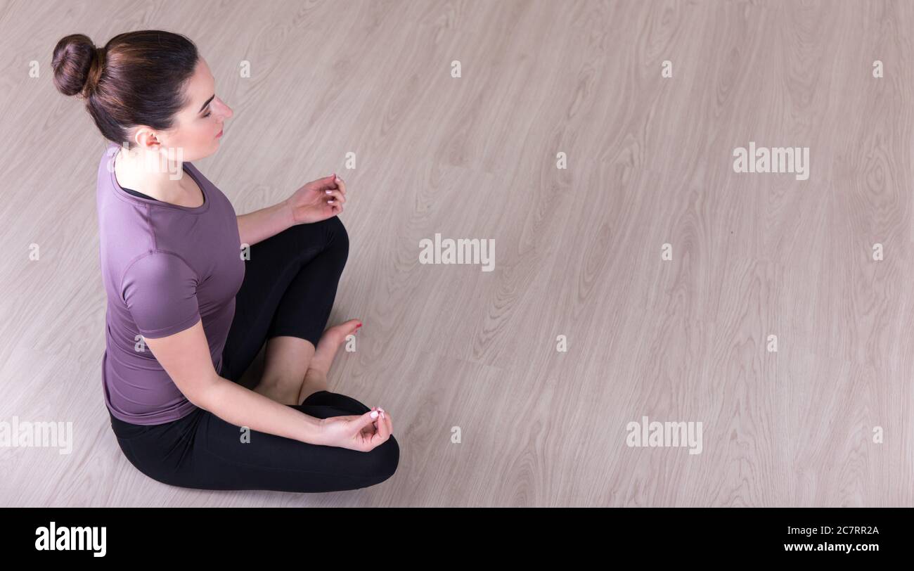 top view of young slim woman sitting in yoga pose on the floor Stock ...