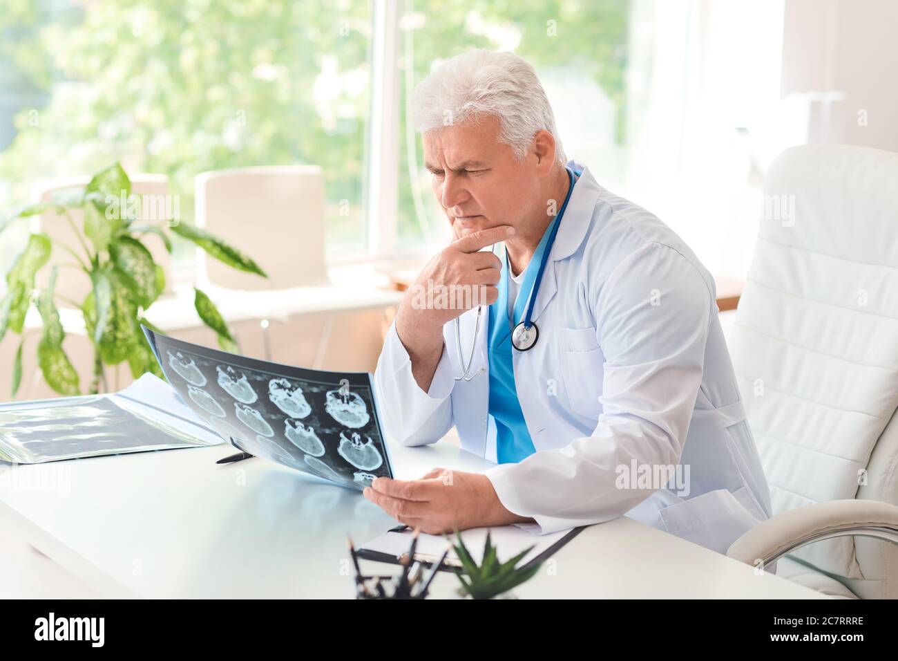 Senior neurologist with MRI scan of human head in clinic Stock Photo ...