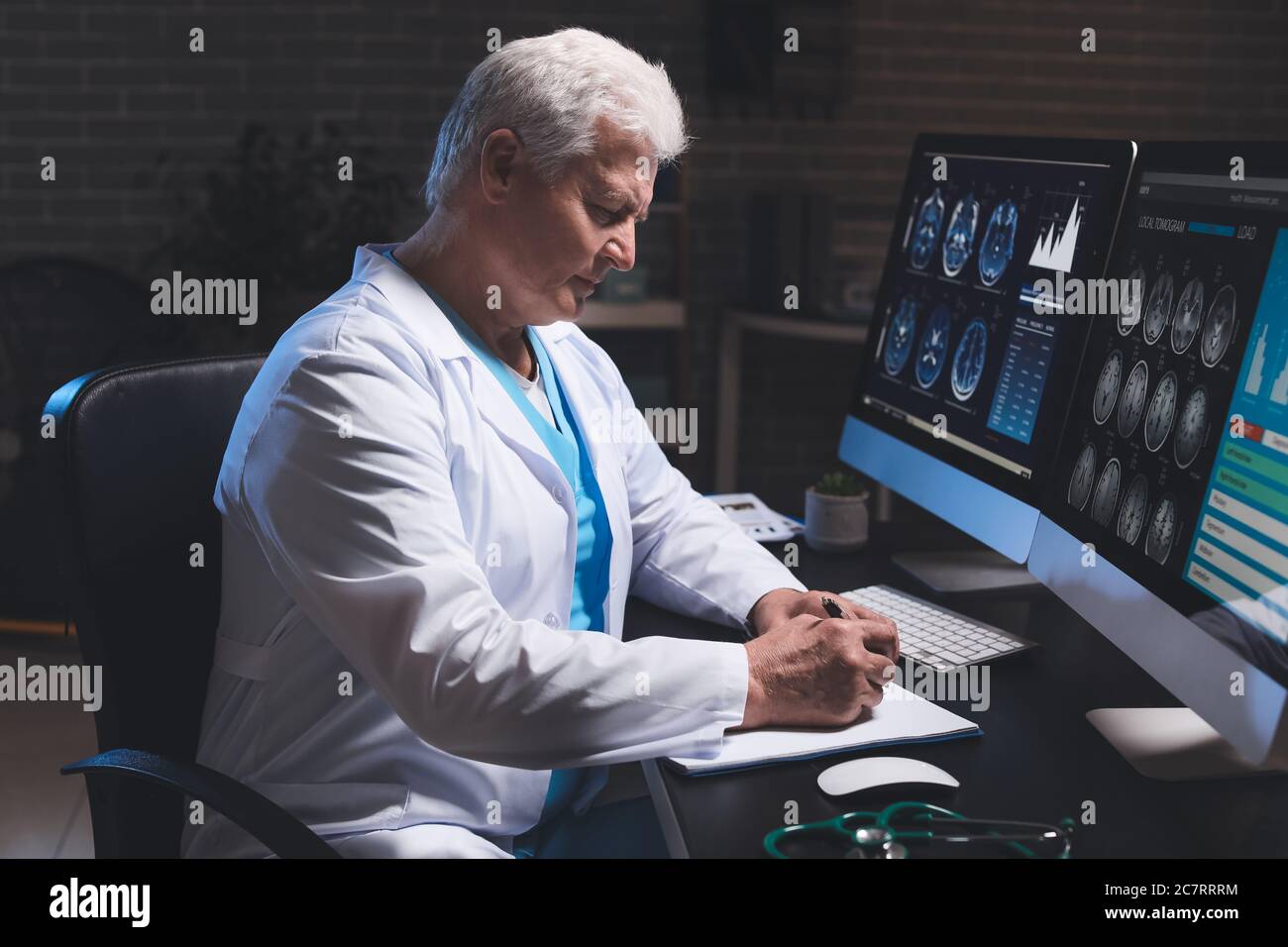 Senior neurologist with MRI scan of human head in clinic Stock Photo ...
