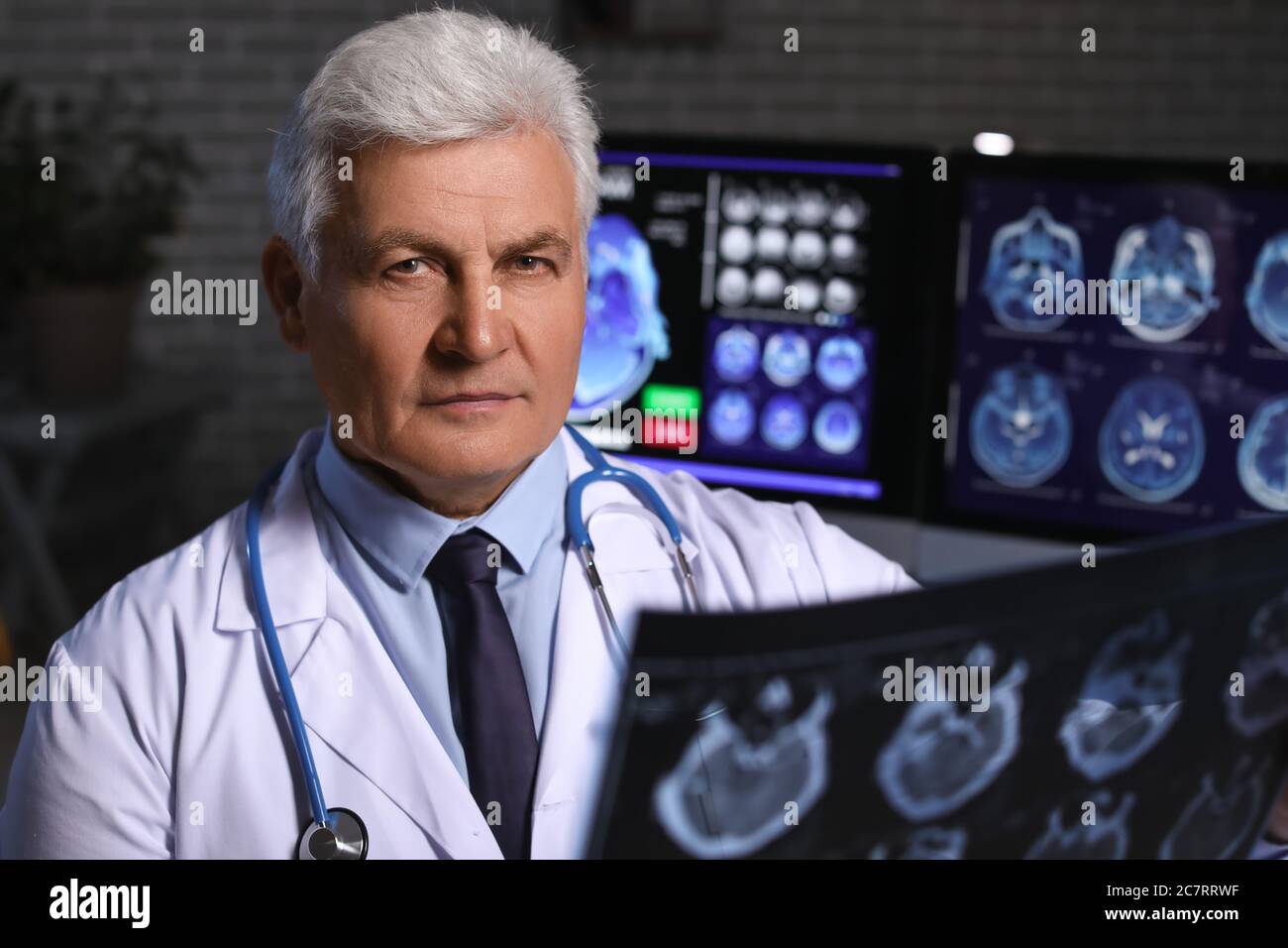 Senior neurologist with MRI scan of human head in clinic Stock Photo ...