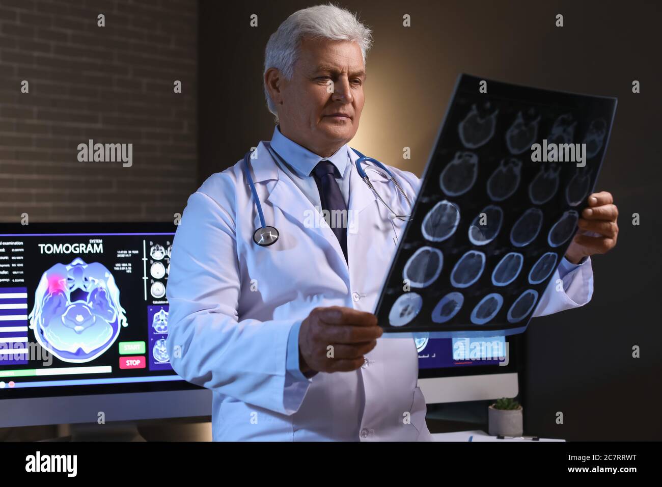 Senior neurologist with MRI scan of human head in clinic Stock Photo ...