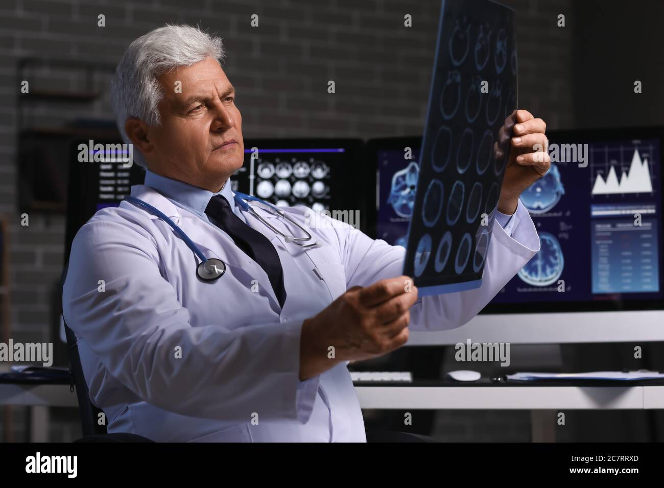 Senior neurologist with MRI scan of human head in clinic Stock Photo ...