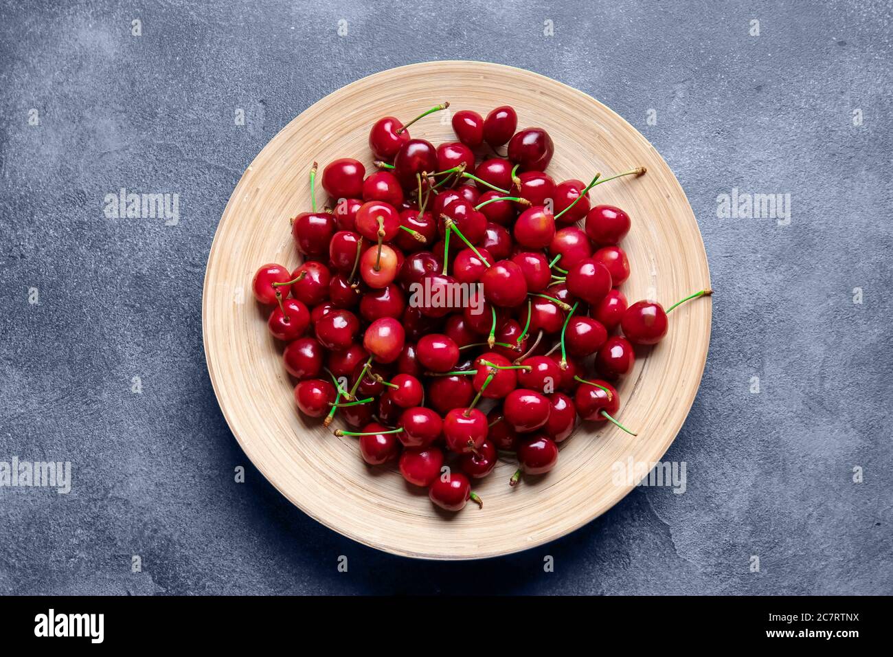 Plate with sweet cherry on table Stock Photo - Alamy