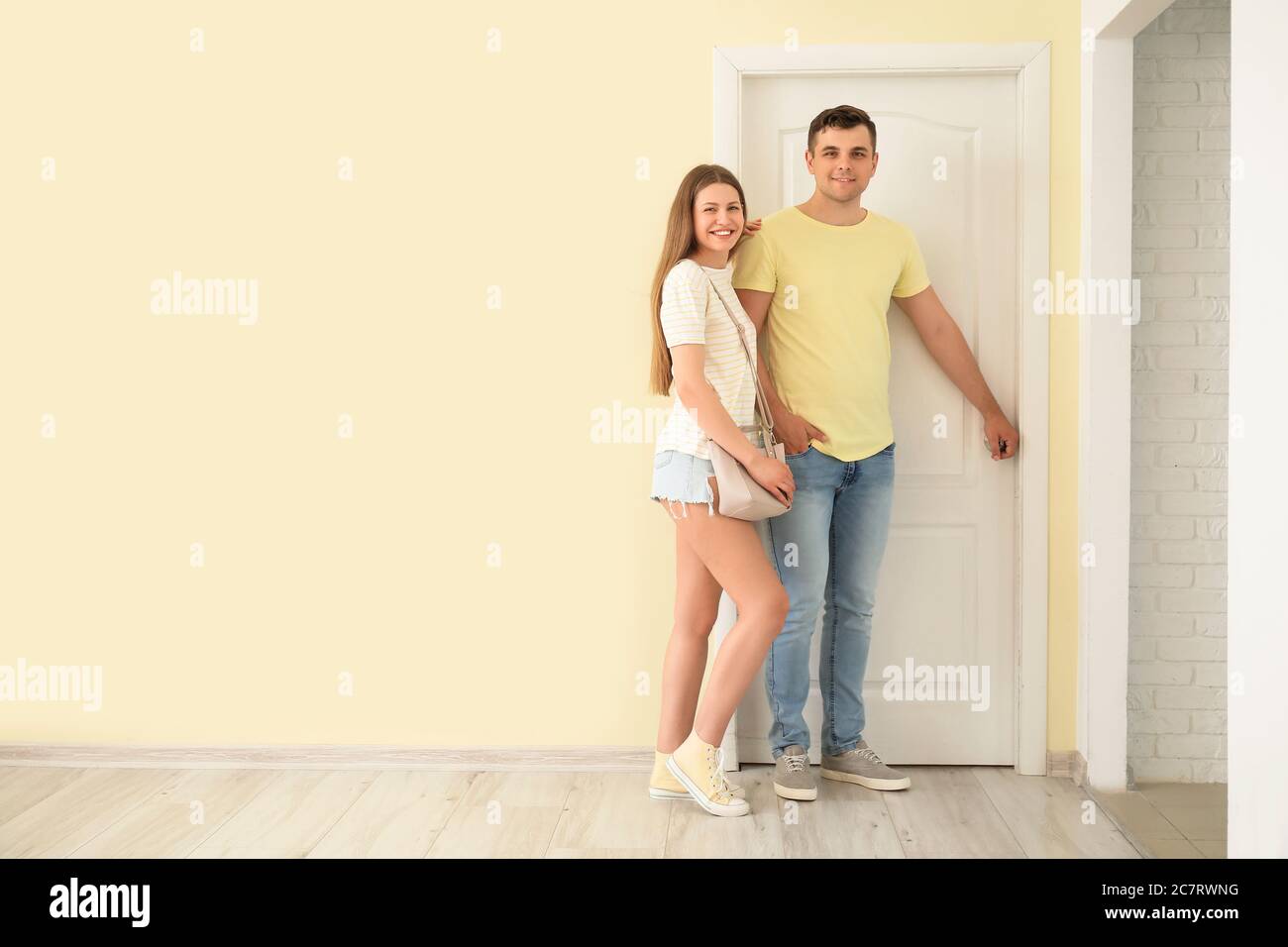 Happy couple in front of door at their new home Stock Photo - Alamy