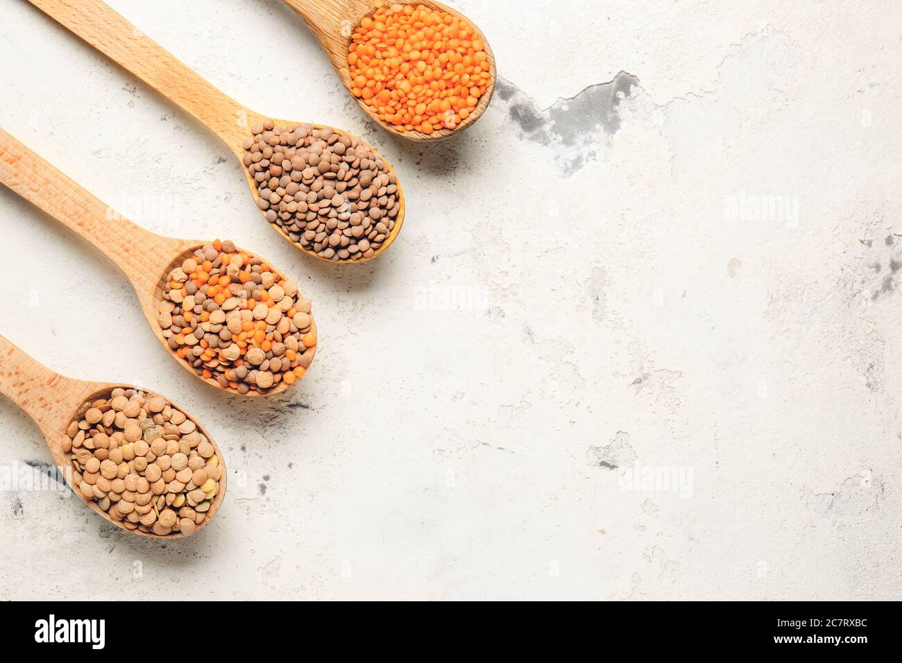 Spoons with lentils on white background Stock Photo - Alamy