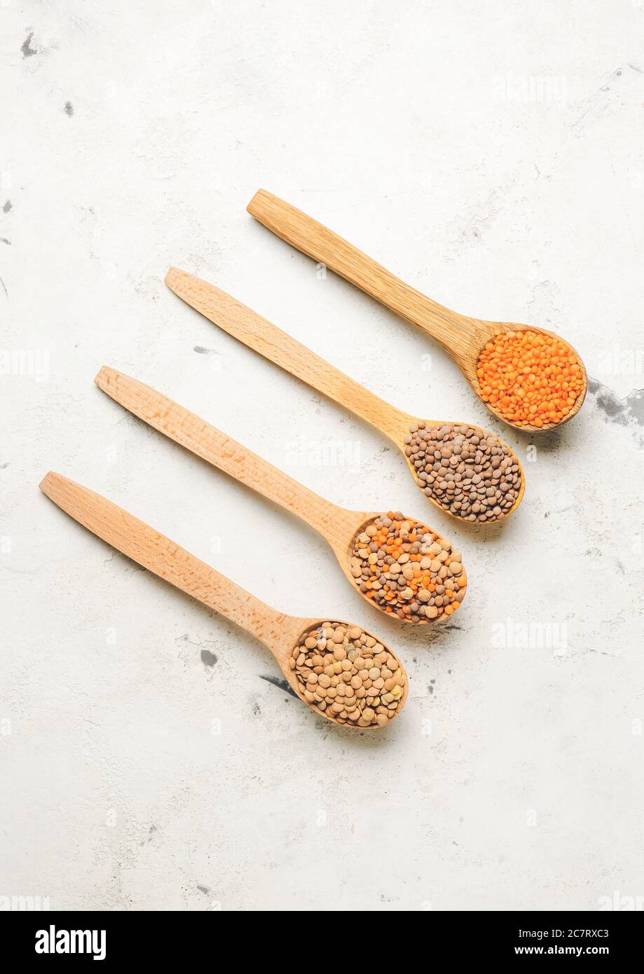 Spoons with lentils on white background Stock Photo - Alamy
