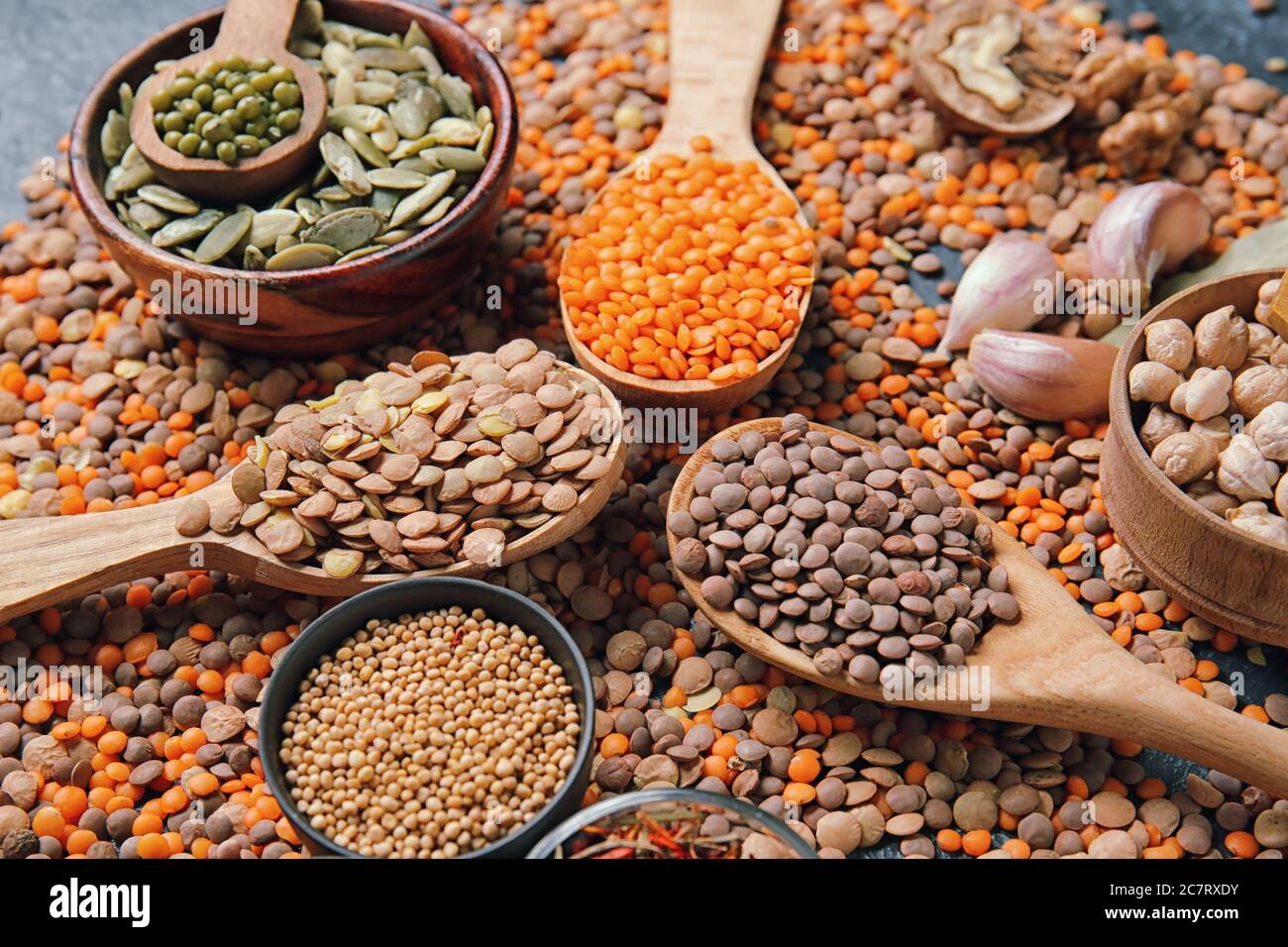 Different raw legumes with spices on dark background Stock Photo - Alamy