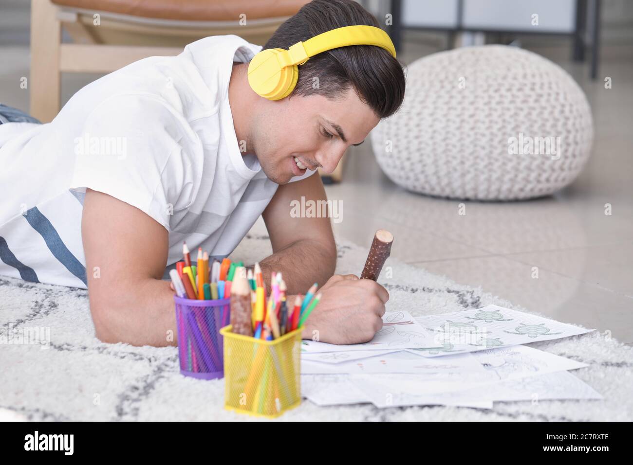 Young man coloring pictures at home Stock Photo - Alamy